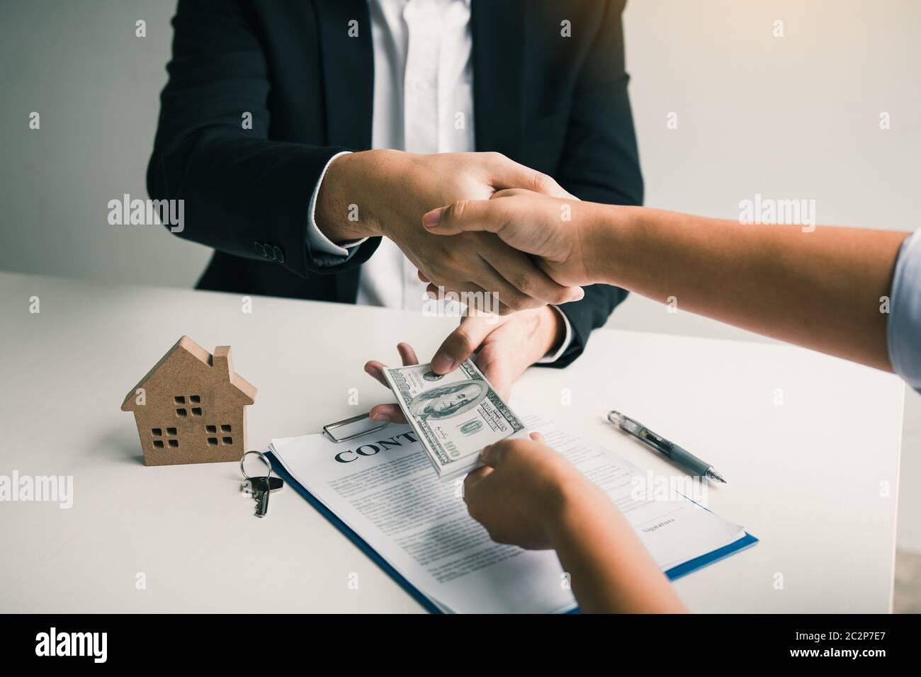 Home sales agents and buyers work on signing new homes and shaking ...