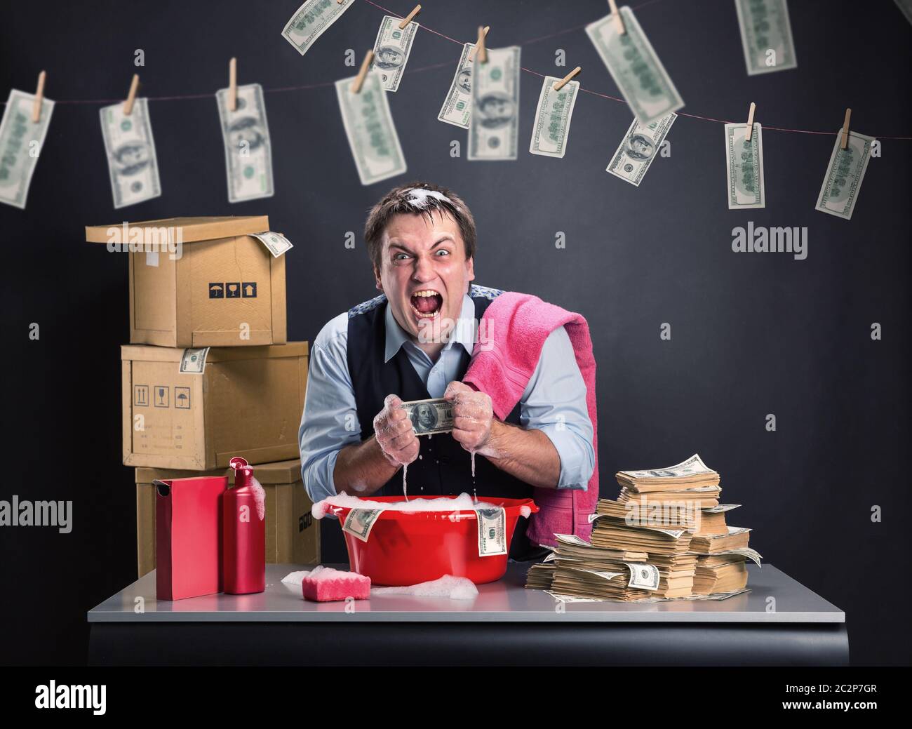 Crazy businessman is laundering money banknotes in foam in red washbowl ...