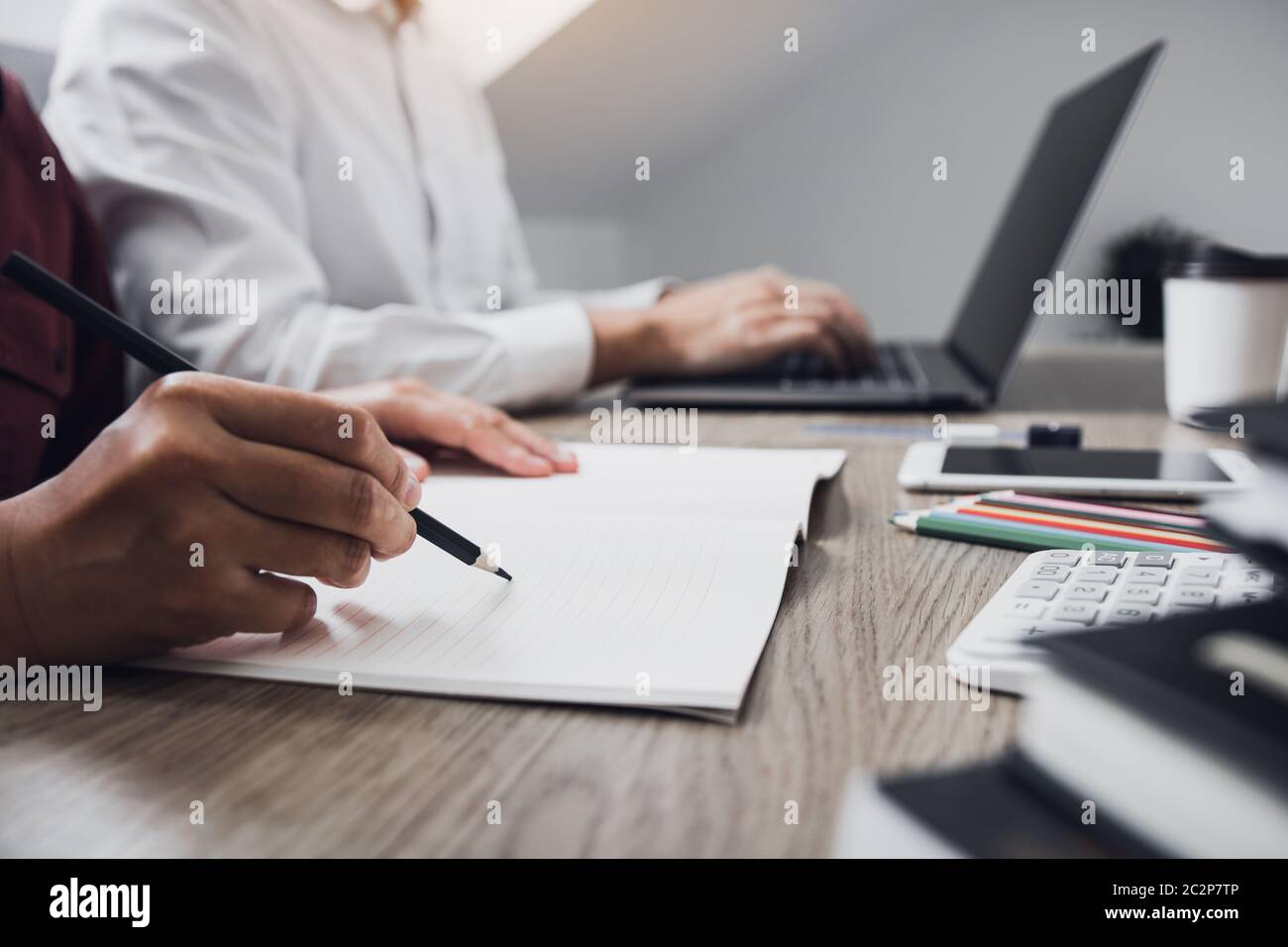 Two student reading textbook for test together in library Stock Photo ...