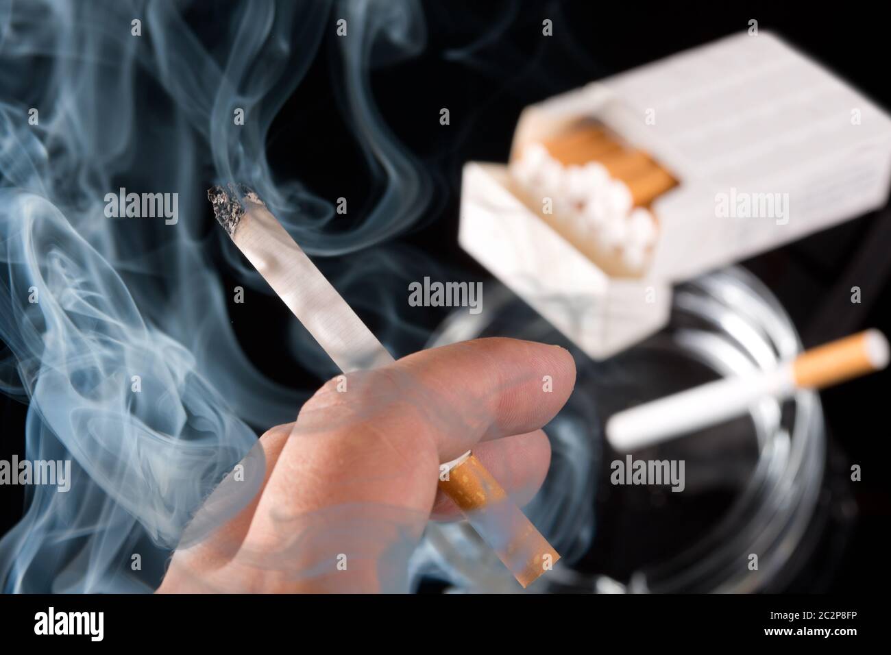 Smokers hand with ashtray and cigarettes pack on background Stock Photo ...