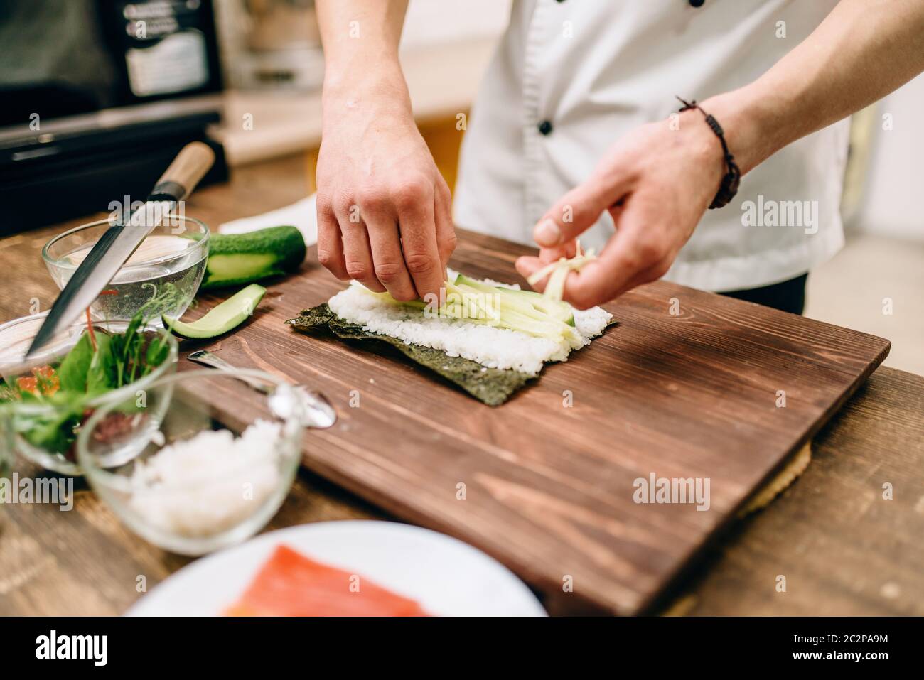 Male cook hands, making sushi rolls, seafood. Traditional japanese ...