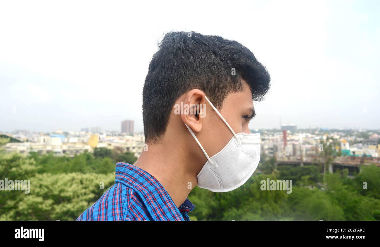 Side view of man wearing face mask on city background Stock Photo - Alamy