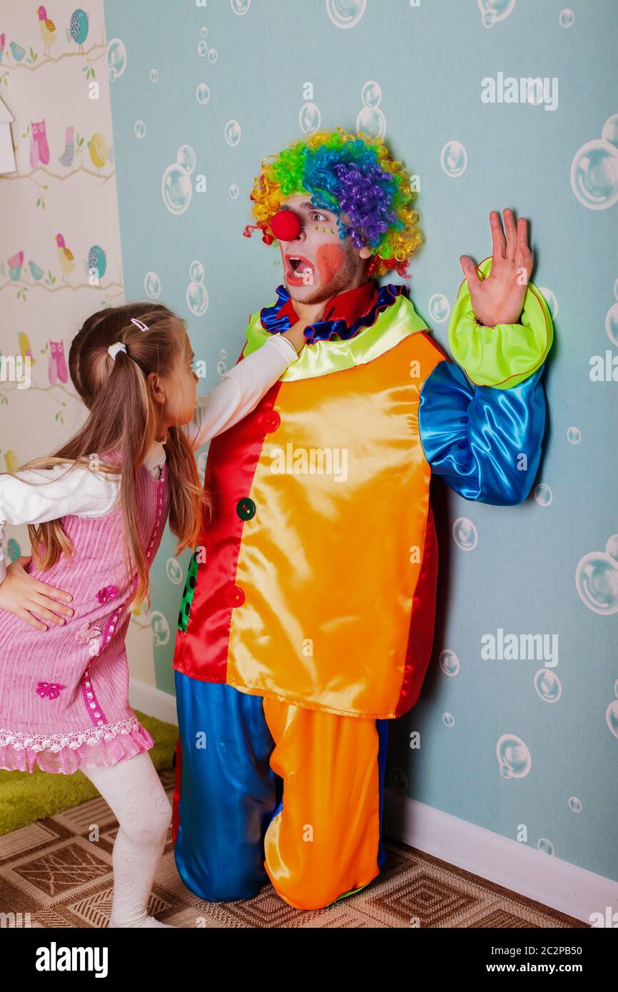 Cruel girl playing with scared clown at her birthday party Stock Photo ...