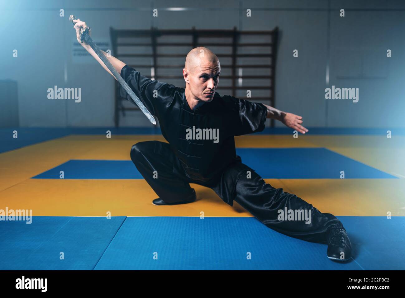 Wushu master training with sword, martial arts. Man in black cloth ...