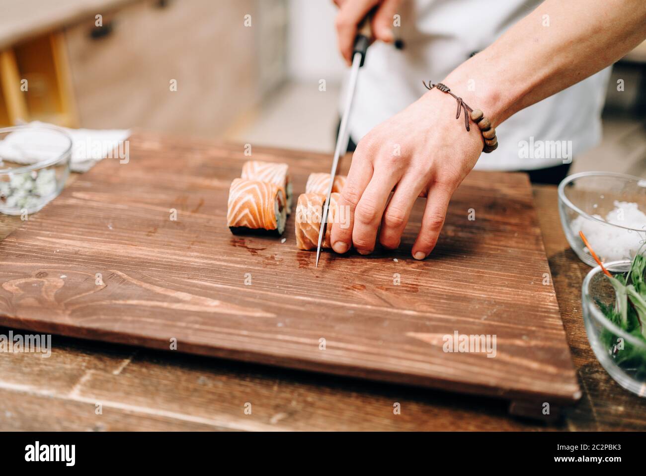 Male person cooking sushi on wooden table, japanese food preparation ...
