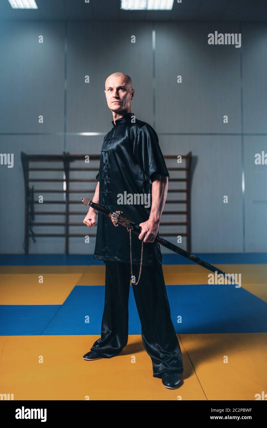 Wushu master training with sword, martial arts. Man in black cloth ...
