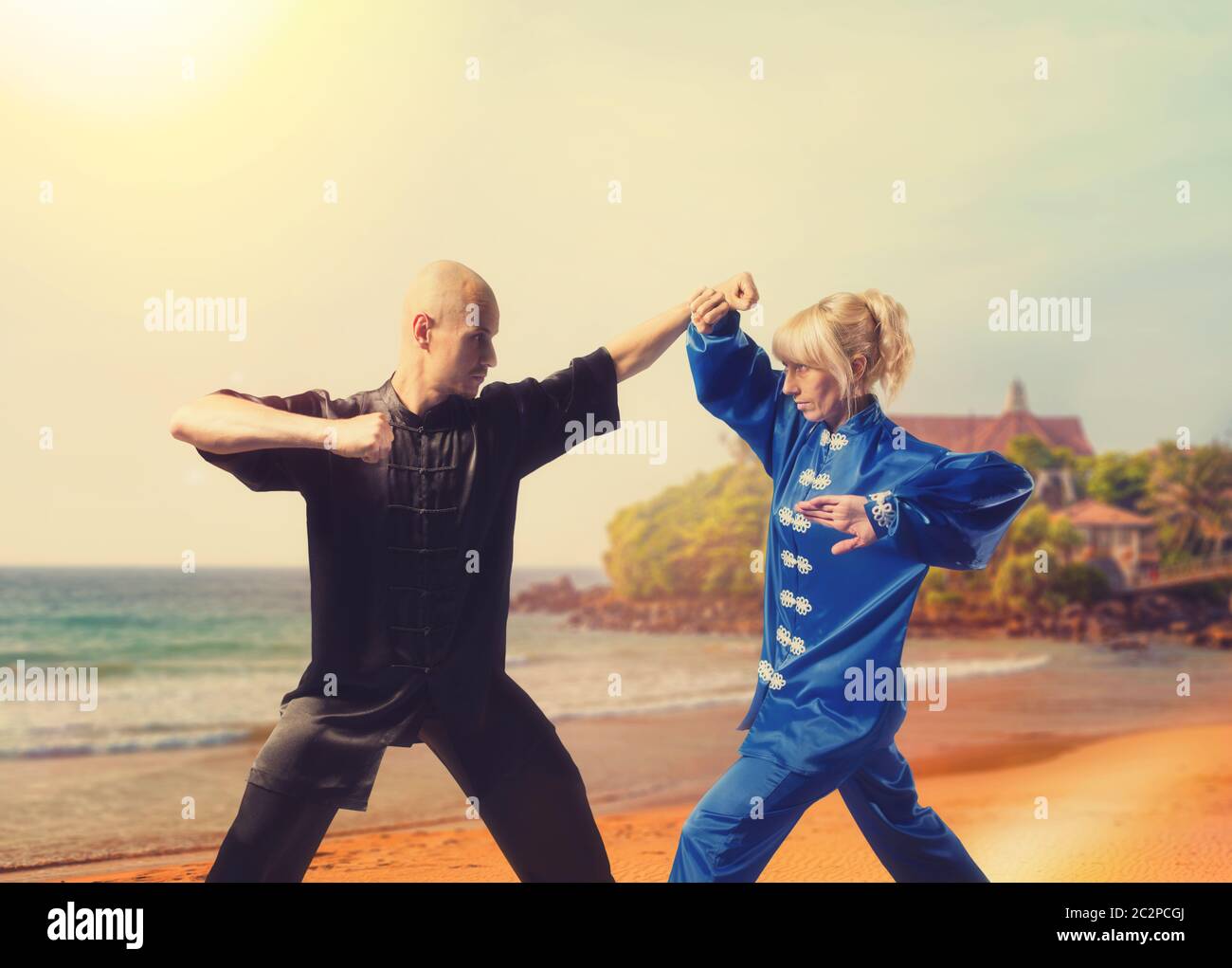 Male and female wushu fighters training on sea coast, martial arts ...