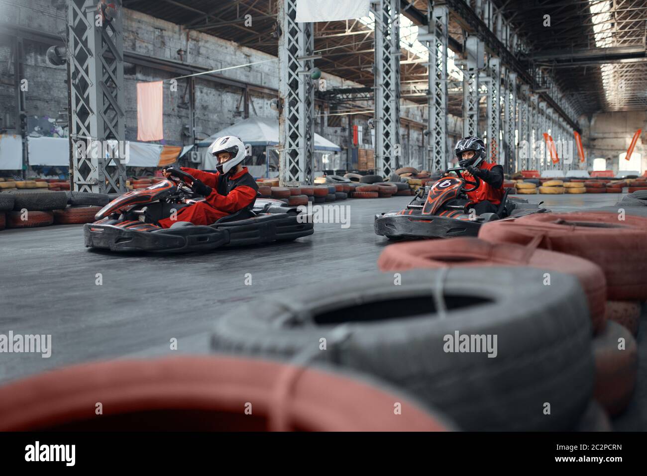 Two kart racers enters the turn, front view, karting auto sport indoor ...