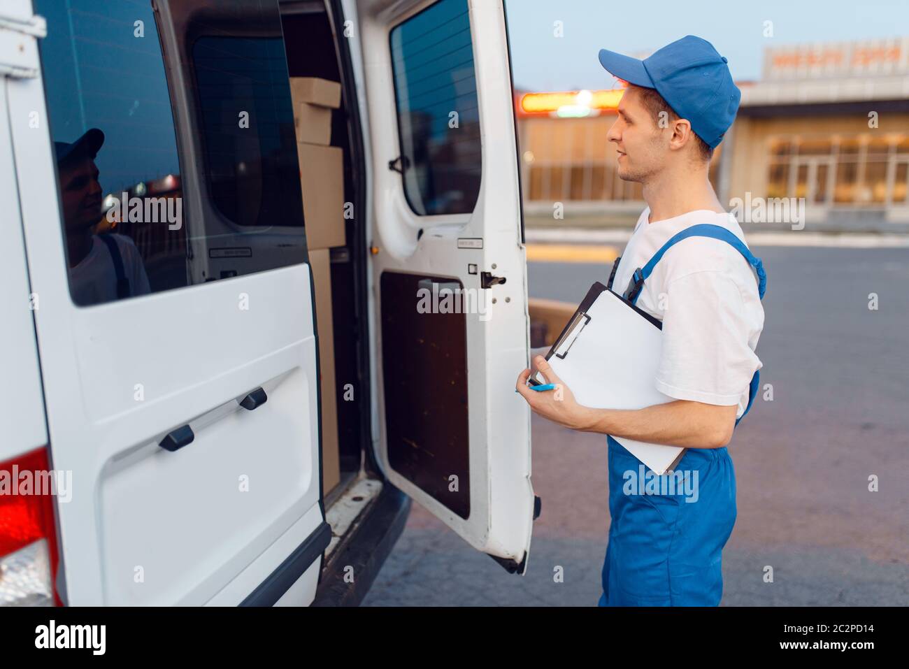 Deliveryman in uniform closing the car, delivery service, delivering ...