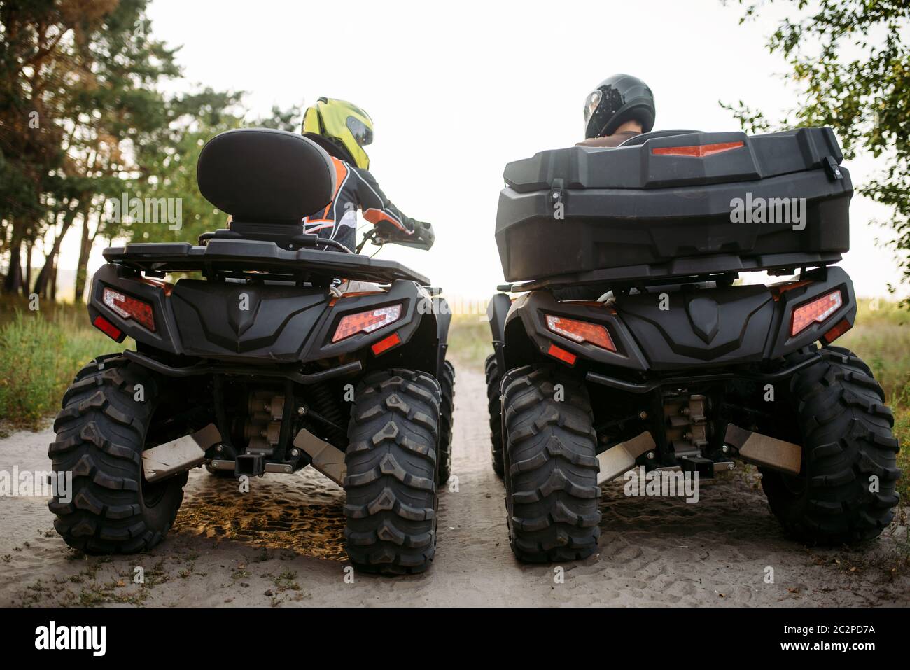 Two atv riders in helmets, back view. Freeriding on quad bike, extreme ...