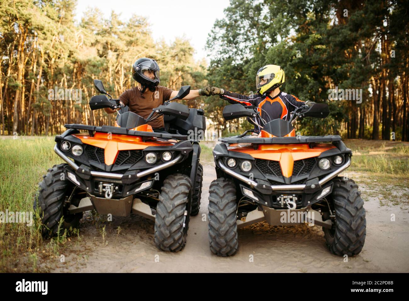 Two atv riders in helmets hits fists for good luck before dangerous ...