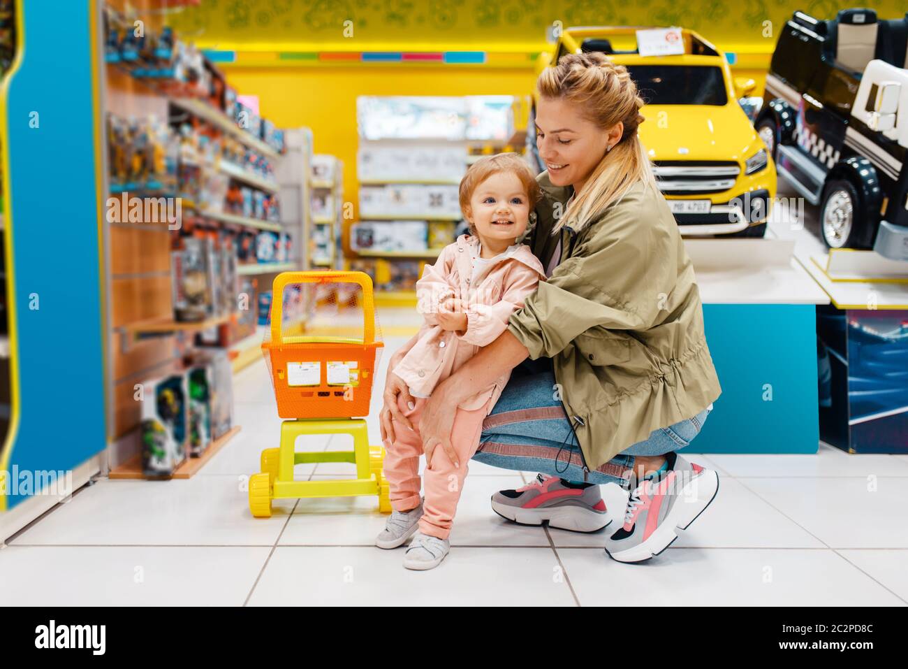 Happy mother with little daughter in kids store. Mom and child together ...