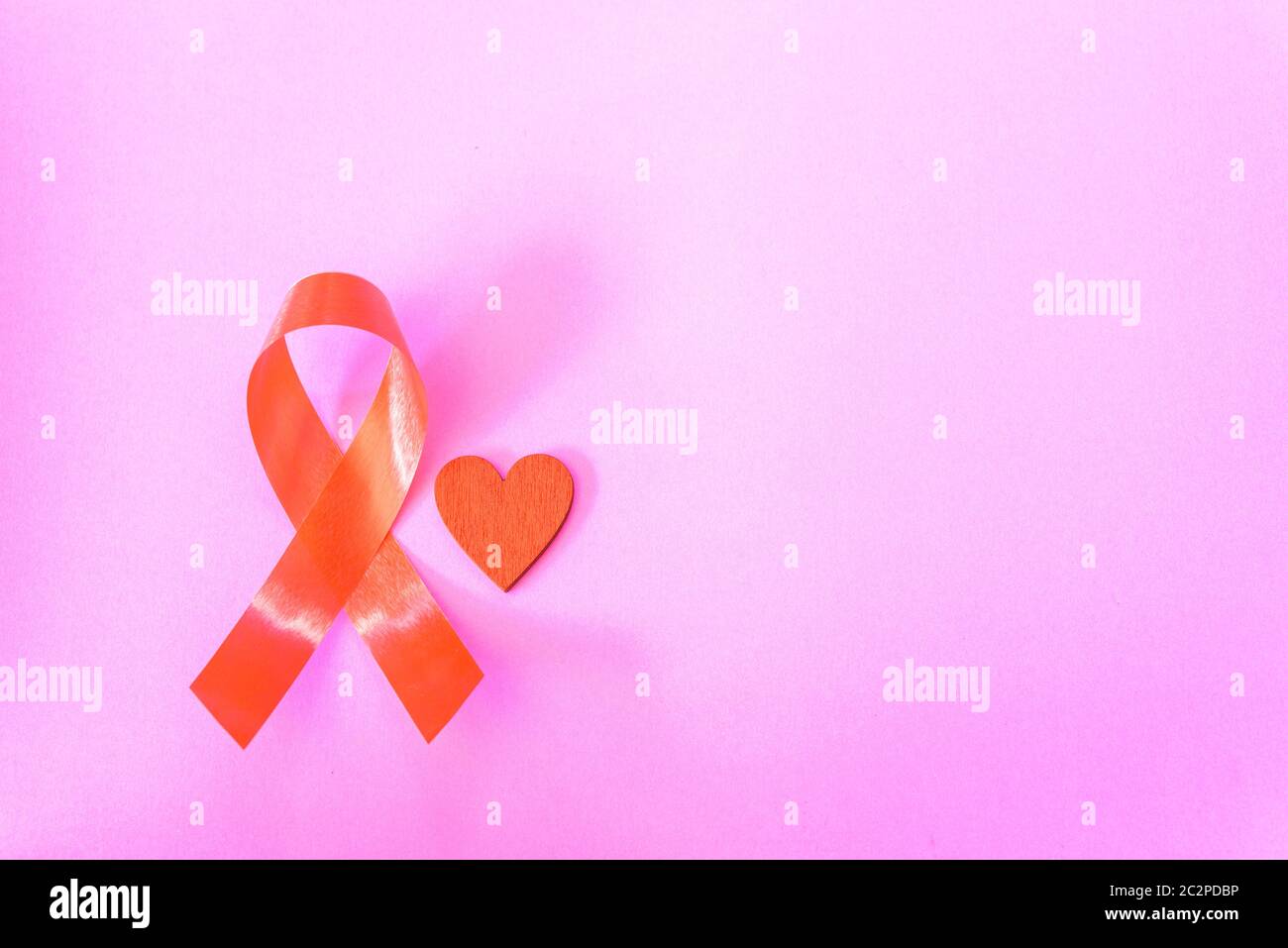 Red Ribbon Support HIV, AIDS on pink background and copy space for use ...