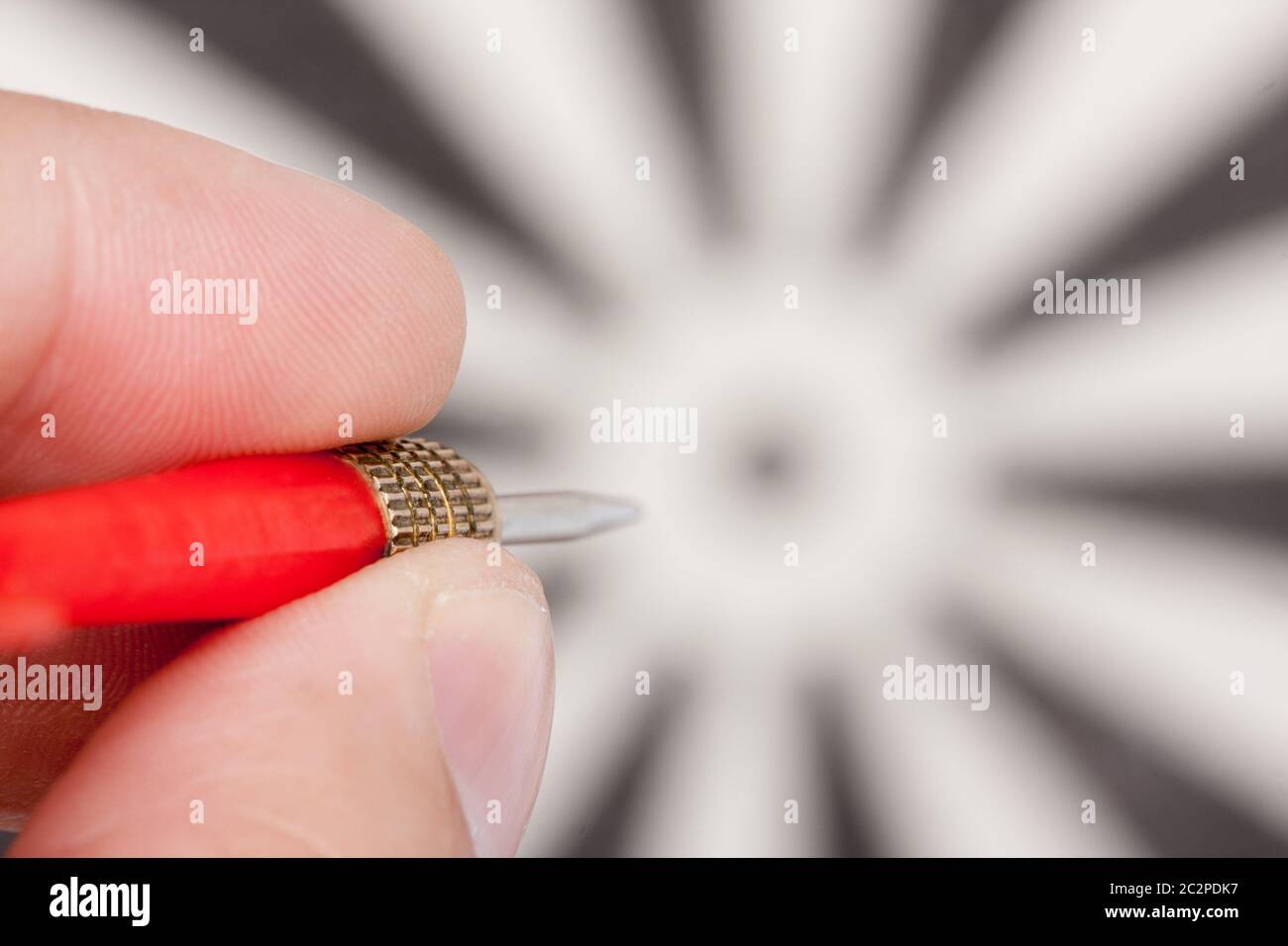 Hand aiming to target by red dart Stock Photo - Alamy