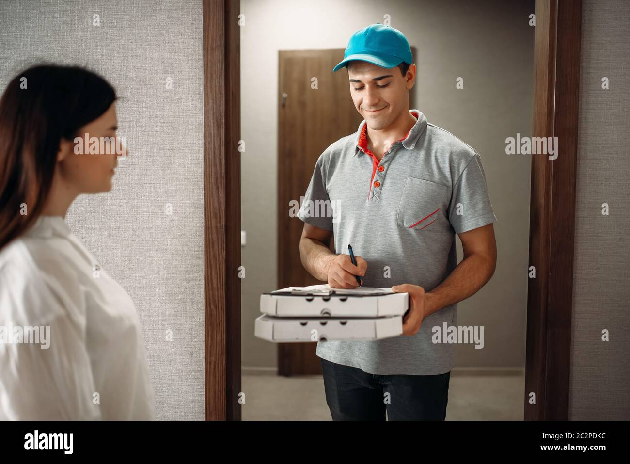 Female customer signs order to pizza delivery boy, fast delivering ...