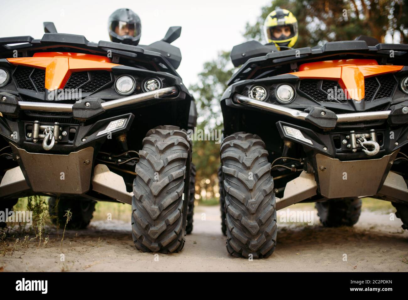 Two riders in helmets and equipment on quad bikes, front view, closeup ...