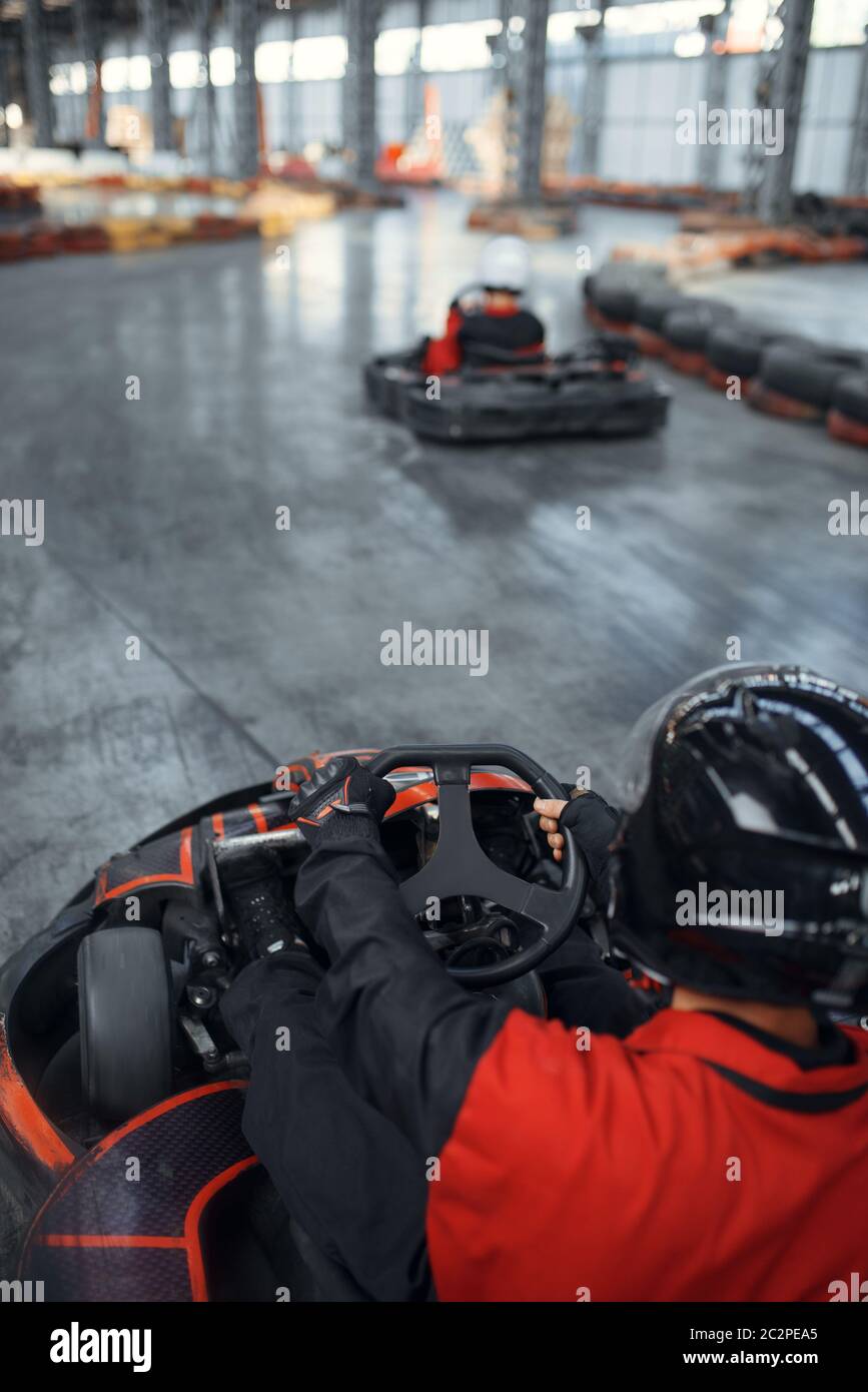 Racer in helmet driving go kart car, back view, karting auto sport ...