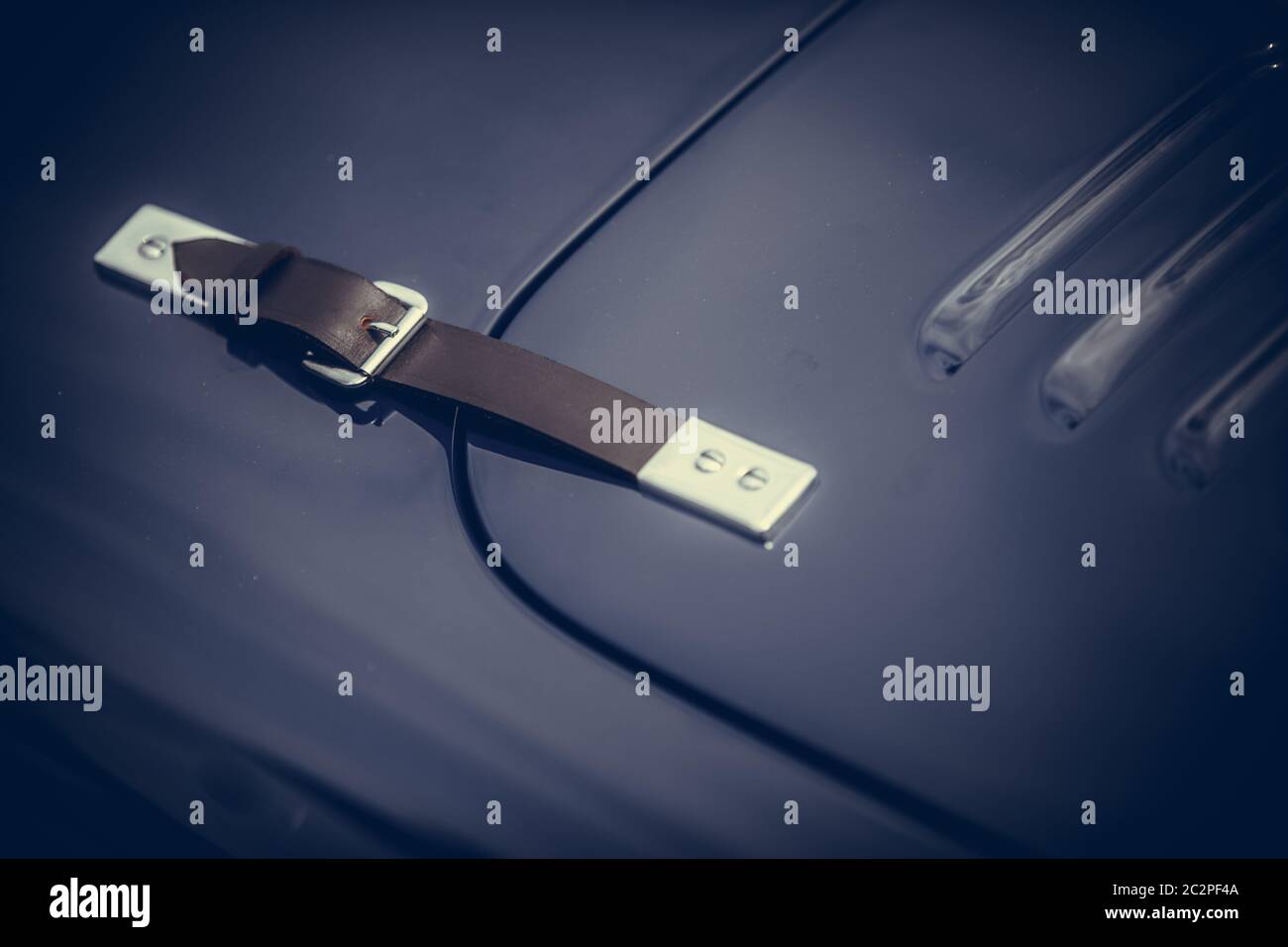 Old classic vintage racing car hood and leather strap Stock Photo - Alamy