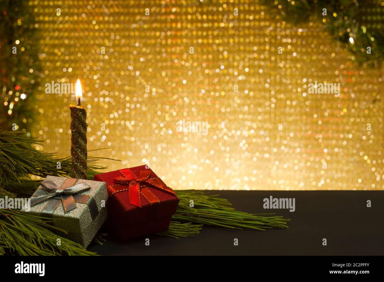 Christmas card. Candle, gift boxes and pine tree branches on golden ...