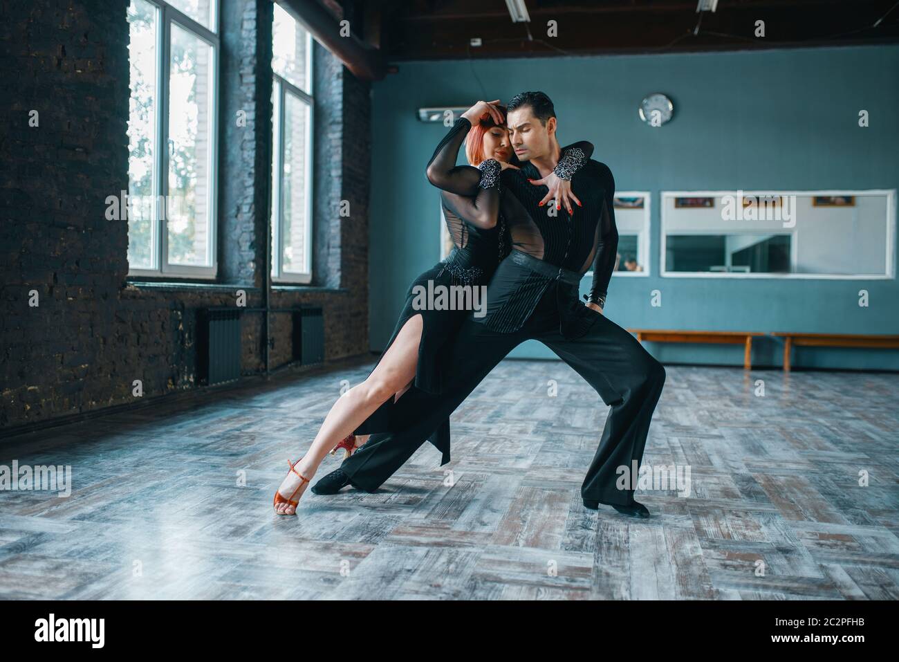 Two dancers in costumes on ballrom dance training in class. Female and ...