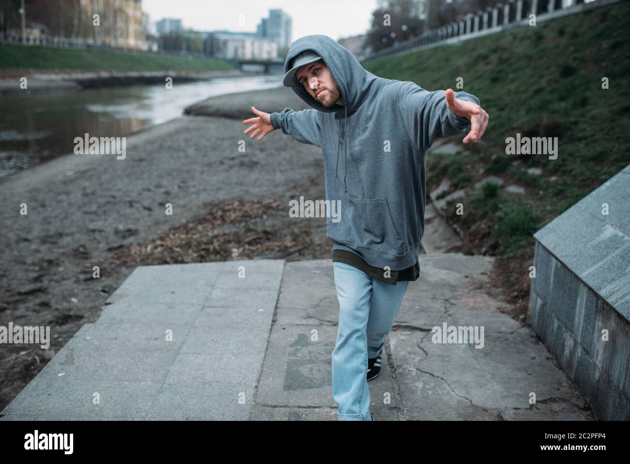 Male rapper posing on the street, urban dancing. Modern dance style ...