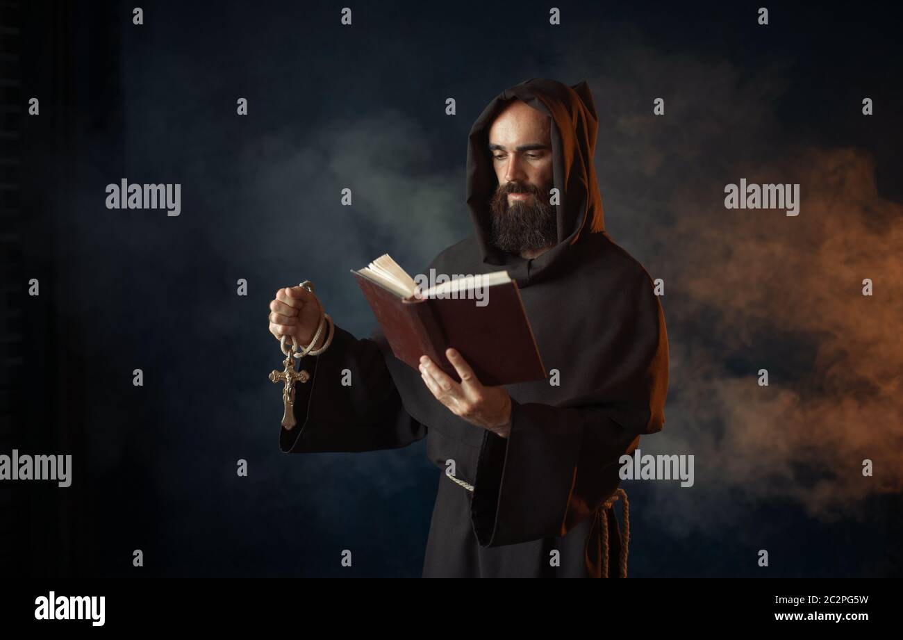 Medieval monk praying with book in hands in church, secret ritual ...