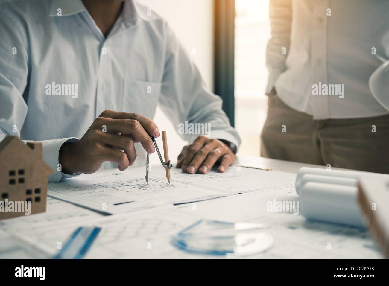 Two architect working at construction site and compass drawing pointing ...