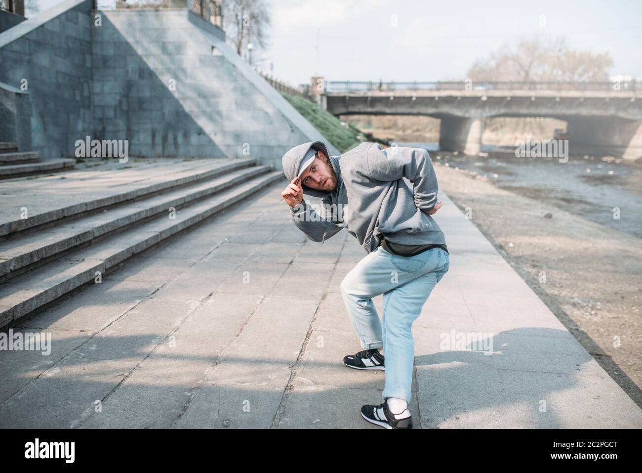 Male rapper posing on the street, urban dancing. Modern dance style ...