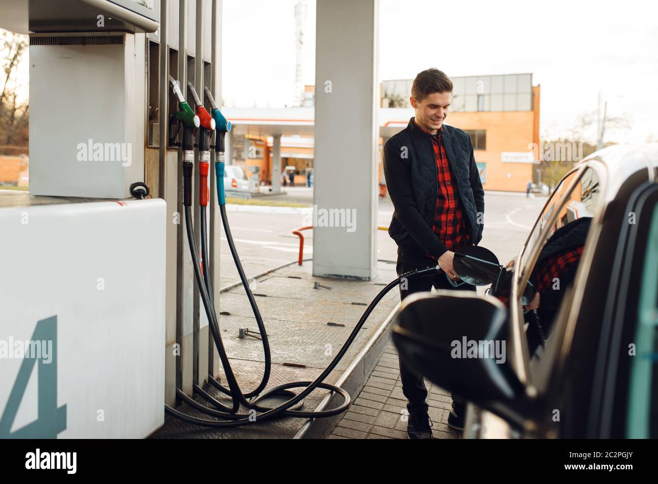 Man with gun fuels vehicle on gas station, fuel filling. Petrol fueling ...