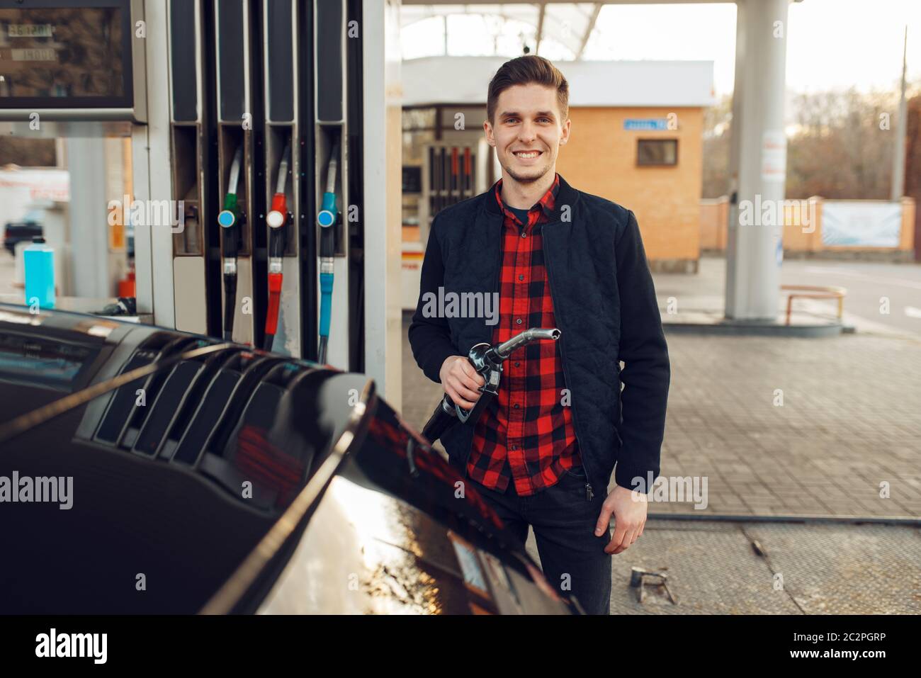 Man with gun fuels vehicle on gas station, fuel filling. Petrol fueling ...