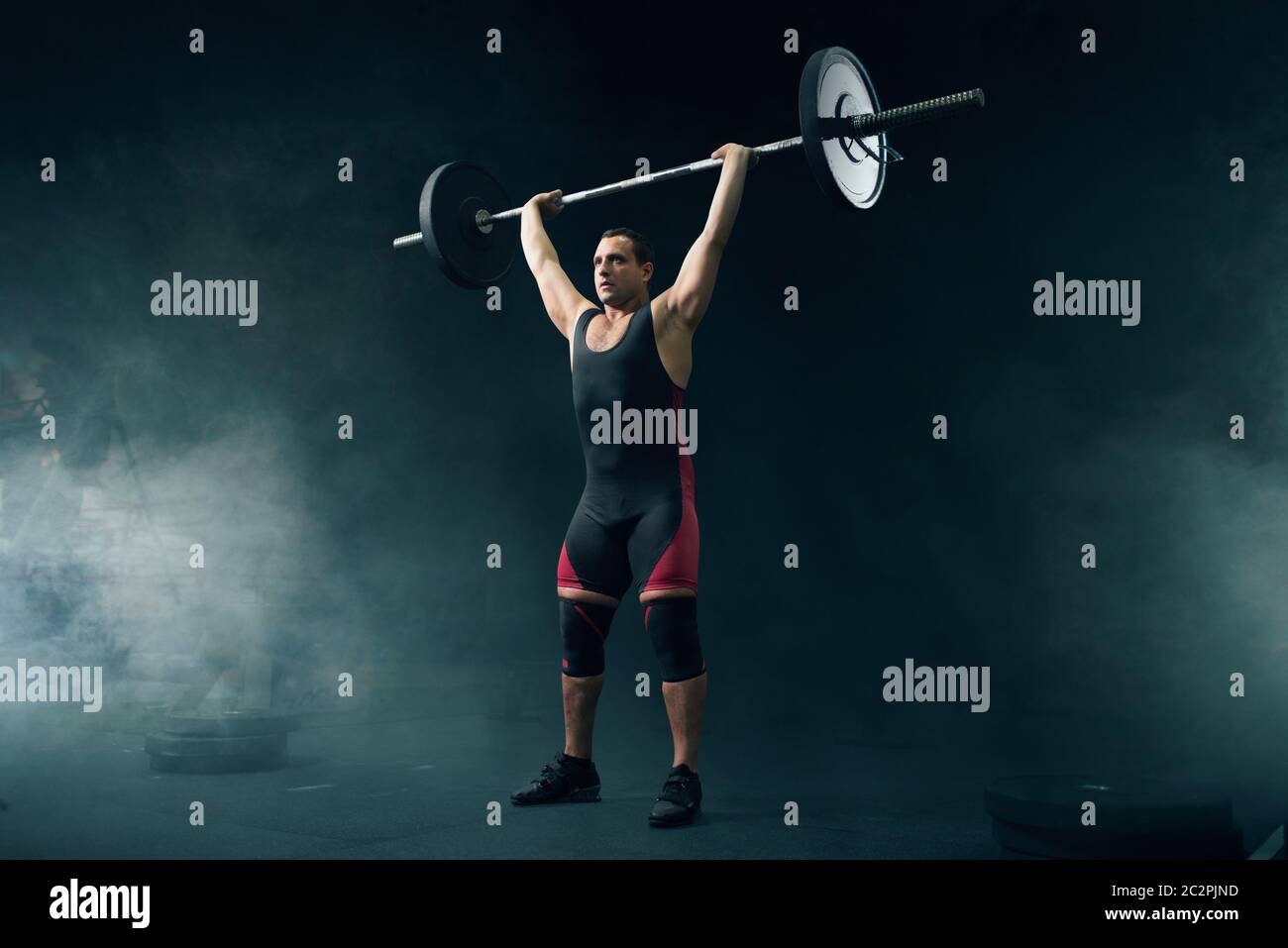 Strong weight lifter in sportswear takes a weight, powerlifter with ...