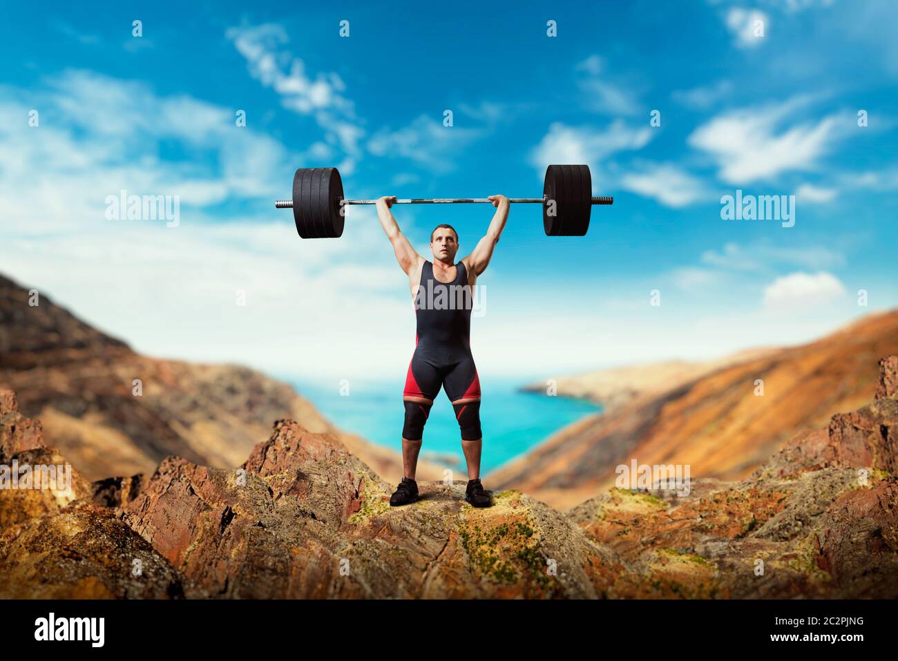 Strong weightlifter takes a weight on the top of mountain, deadlift ...