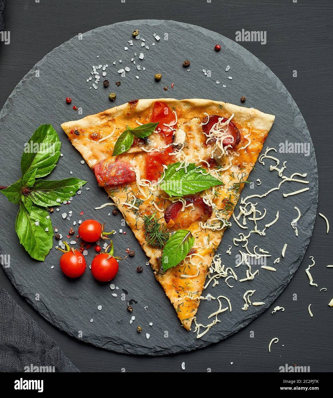 delicious triangular slice of pizza with smoked sausages, mushrooms ...