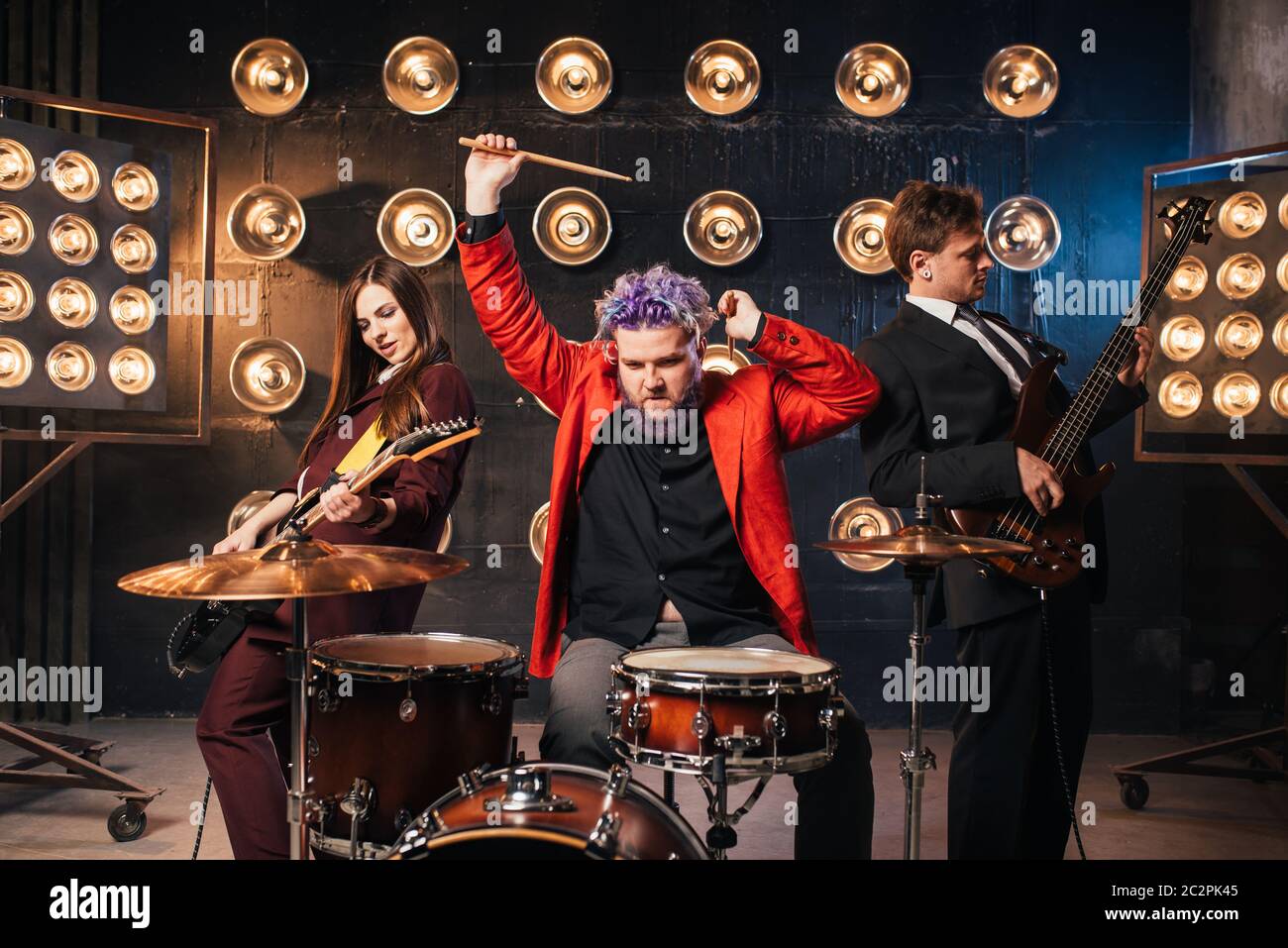 Musicians in suits on the stage with lights, rock band. Guitarists and ...