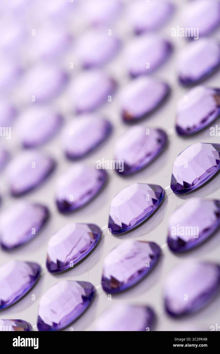 Lilac decorative gems in a row Stock Photo - Alamy