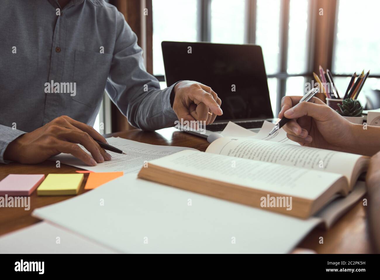 Teenage student works on homework in his room and writing in notebook ...