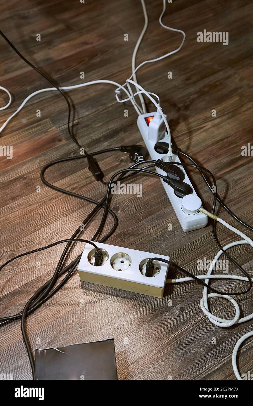 Cables and extension blocks, electreic devices in a mess Stock Photo ...