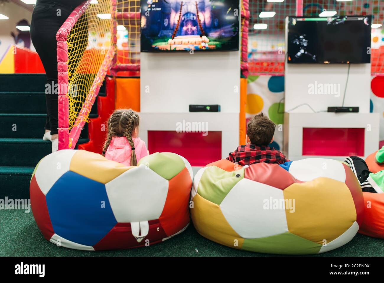 Boy and girl play in a games console in childrens entertainment center ...
