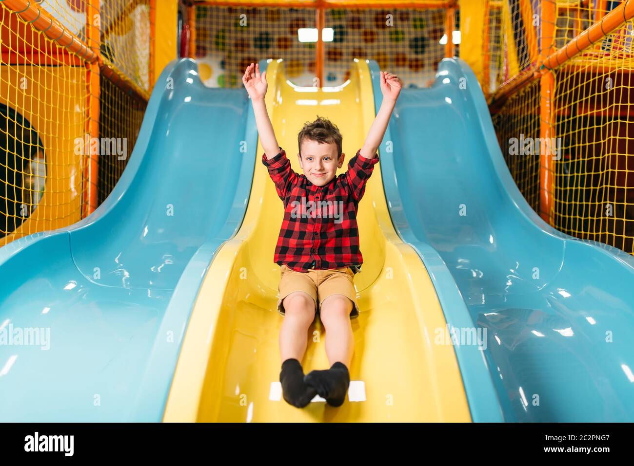 Boy riding from childrens slides on playground, attraction in game ...