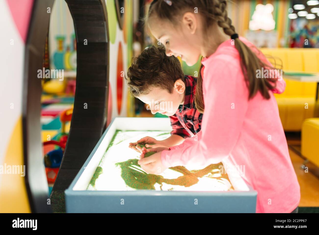 Little kids having fun on attractions in entertainment center. Happy ...