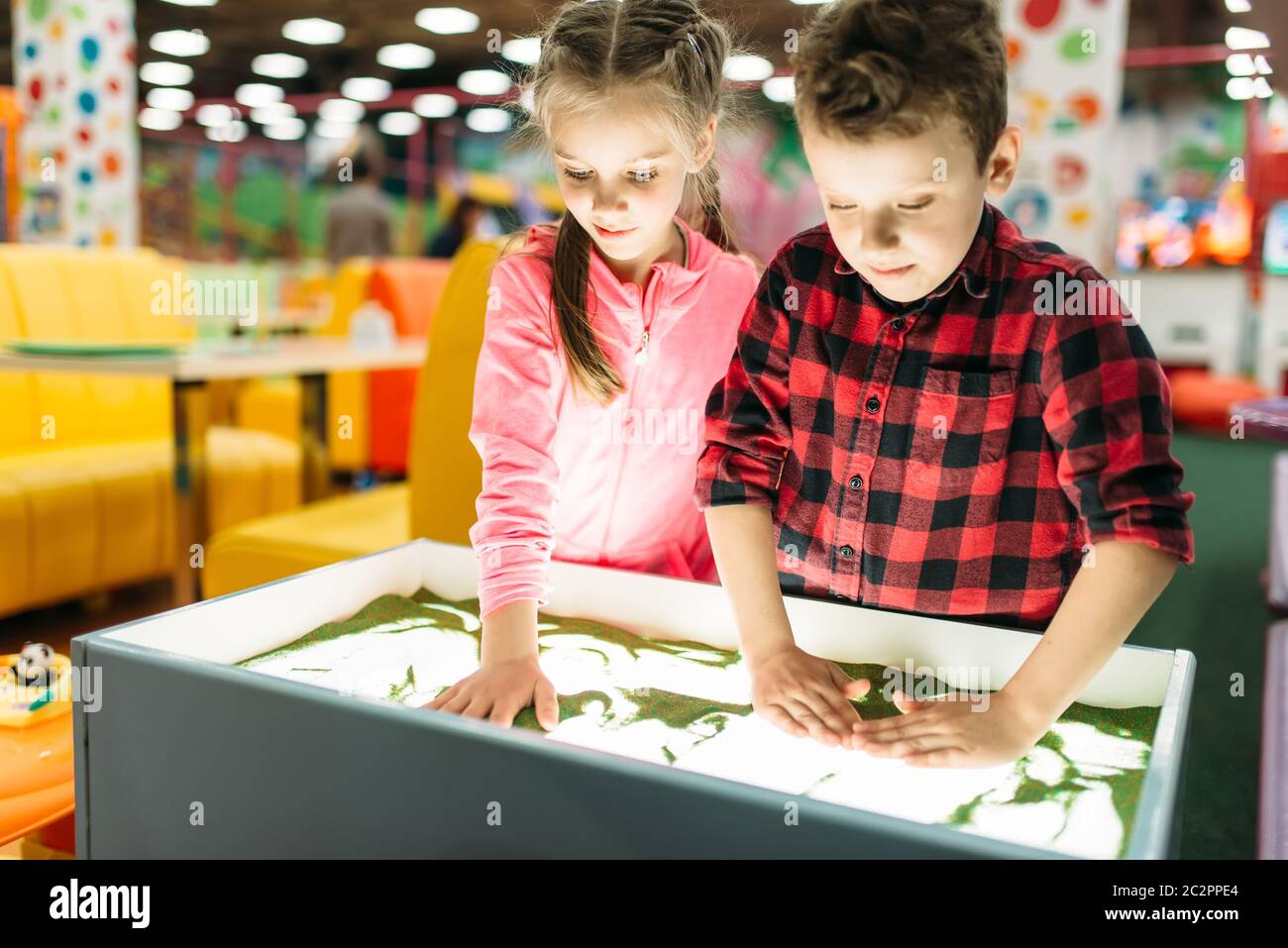 Little kids having fun on attractions in entertainment center. Happy ...