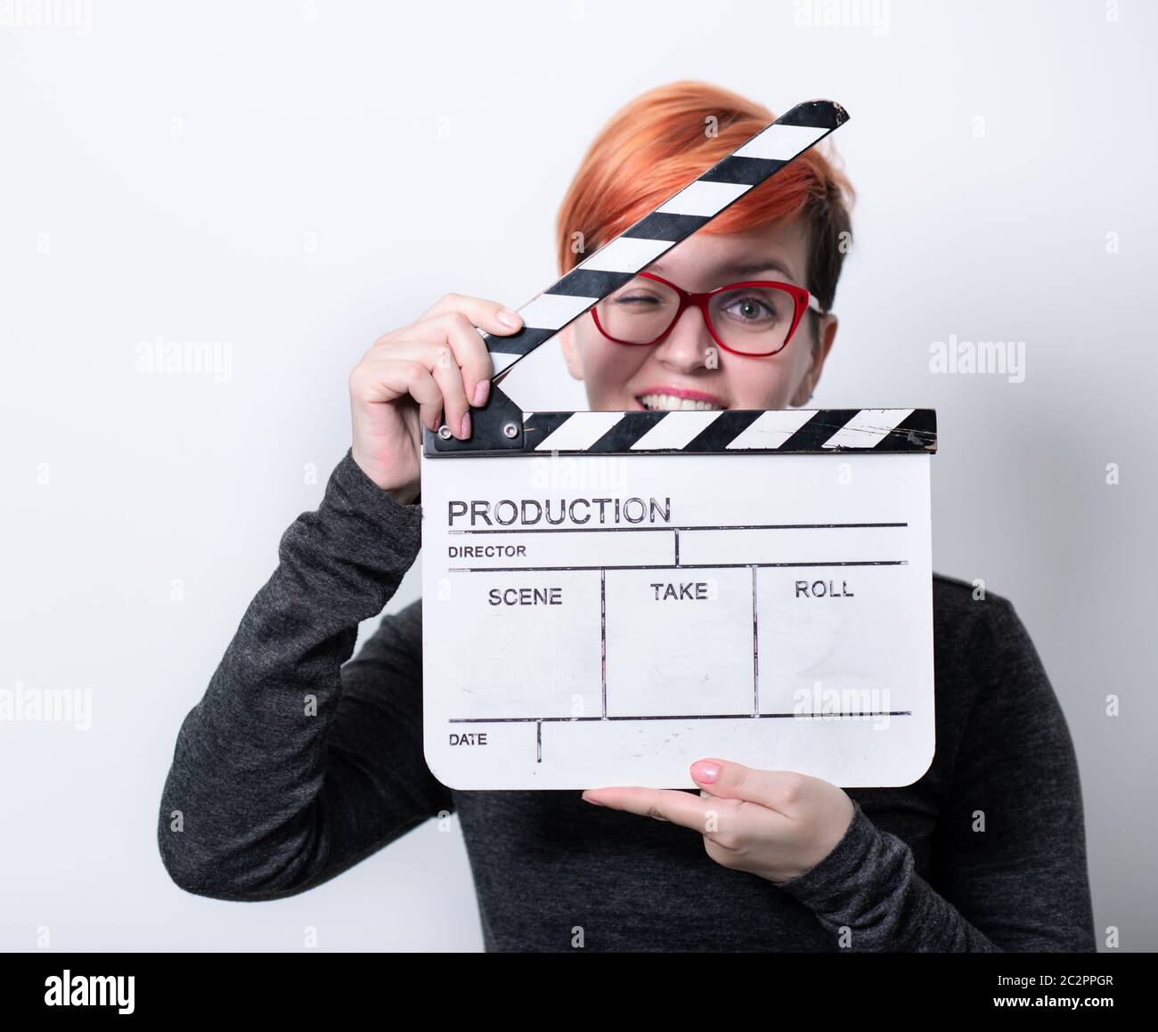 redhead woman holding movie clapper on white background Stock Photo - Alamy