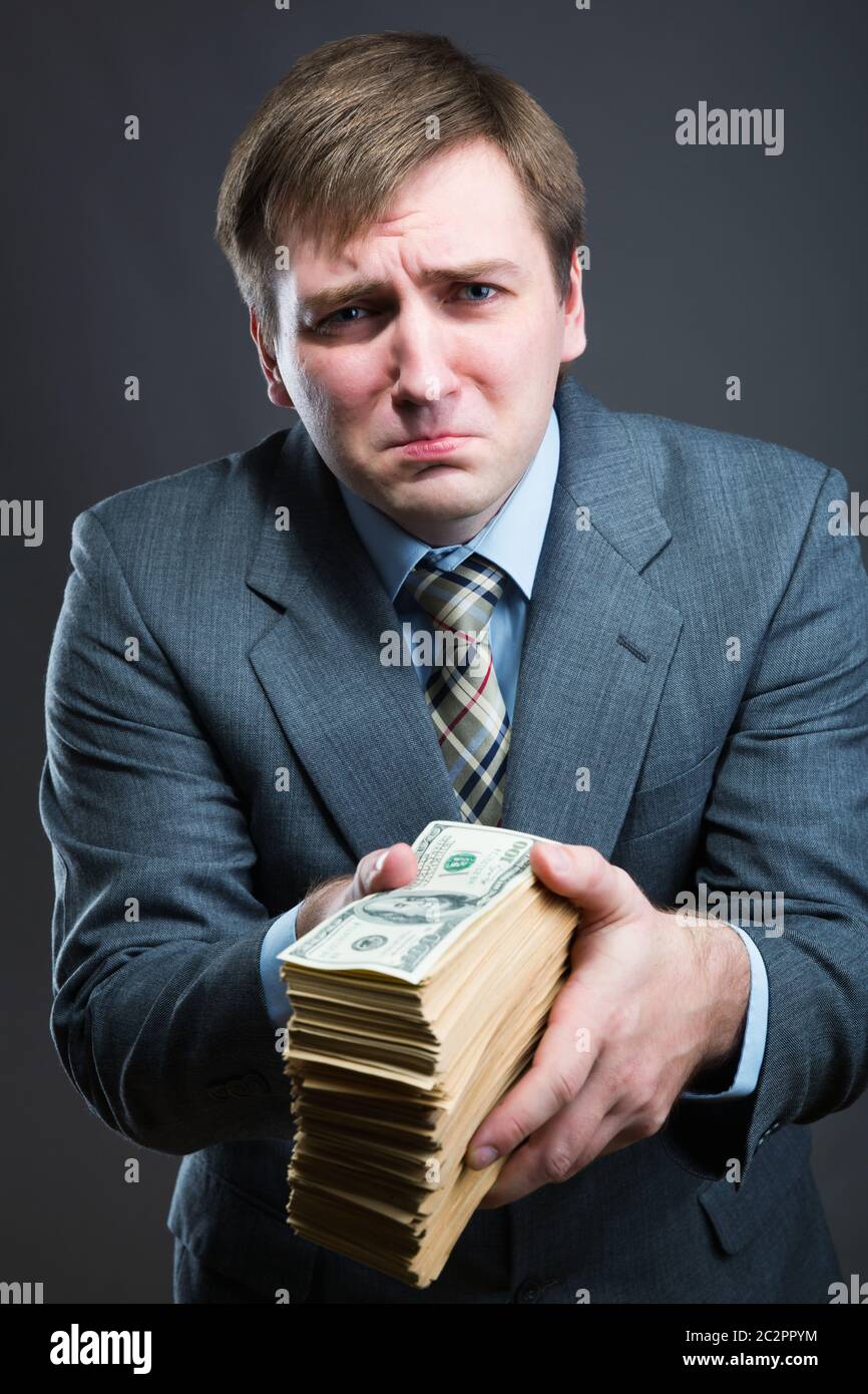 Sad man holding big pack of money Stock Photo - Alamy