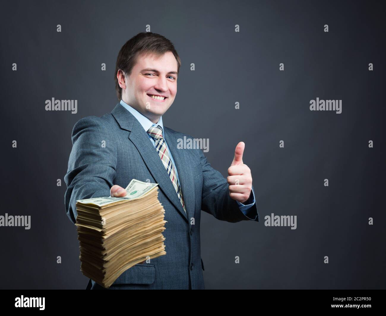Happy businessman holding big pack of money Stock Photo - Alamy