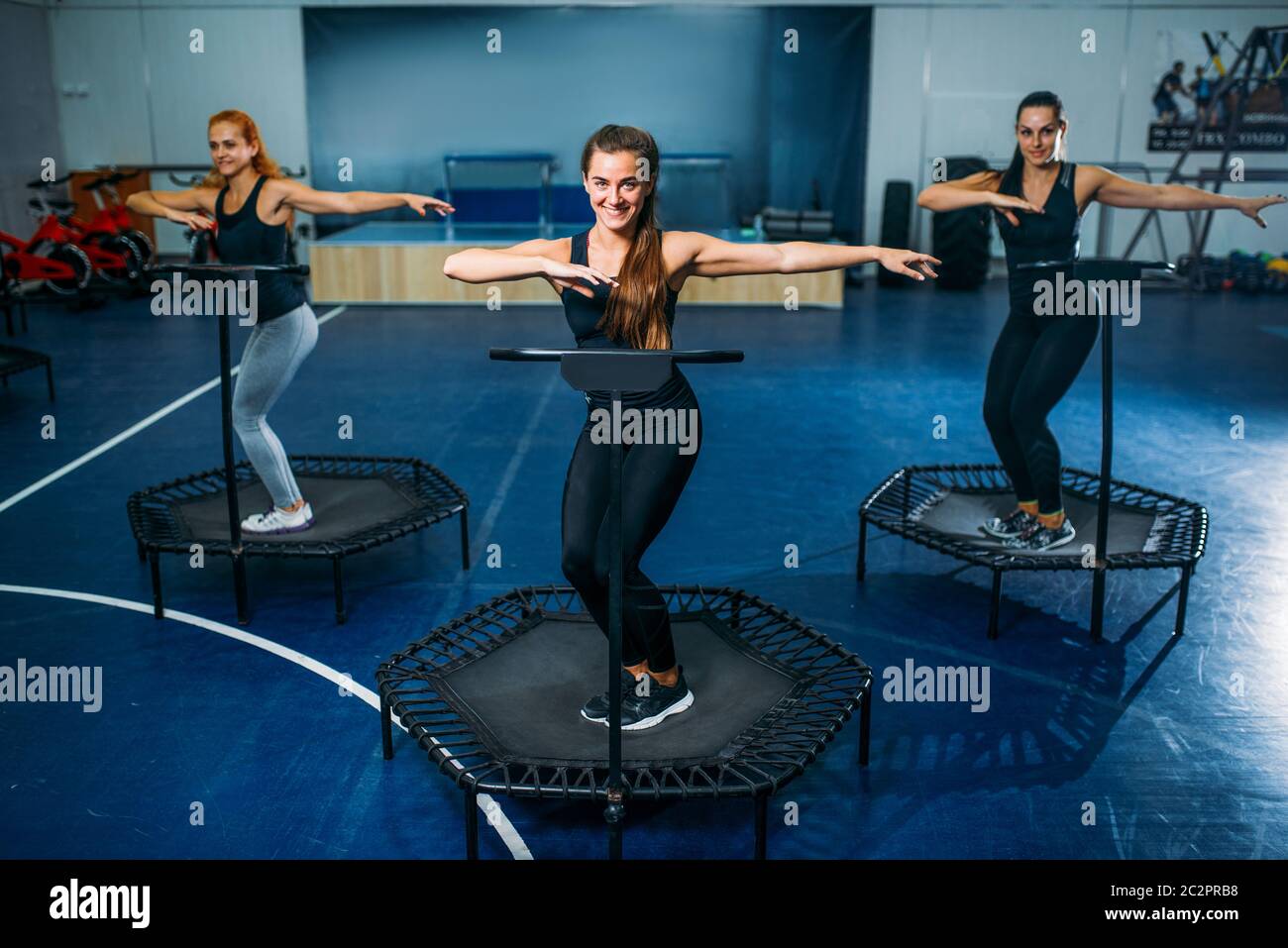Women group on sport trampoline, fitness training. Female teamwork in ...