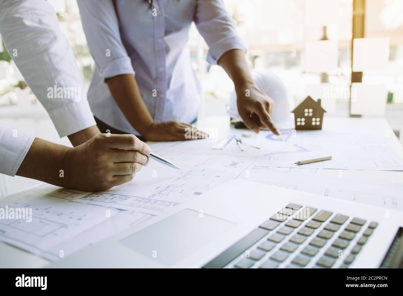 Two architect working at construction site and compass drawing pointing ...