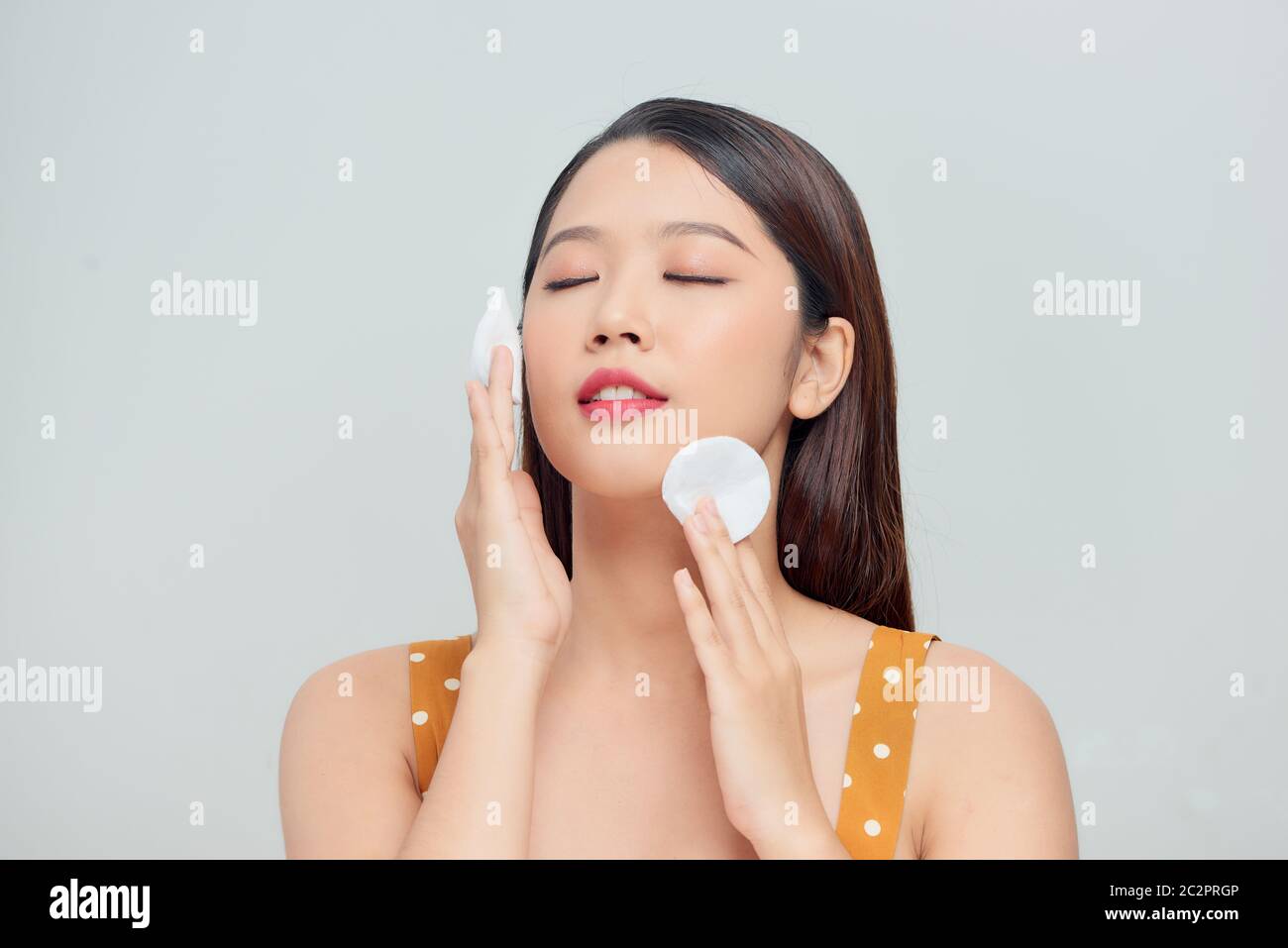 Beautiful woman cleaning face by cotton pad Stock Photo - Alamy
