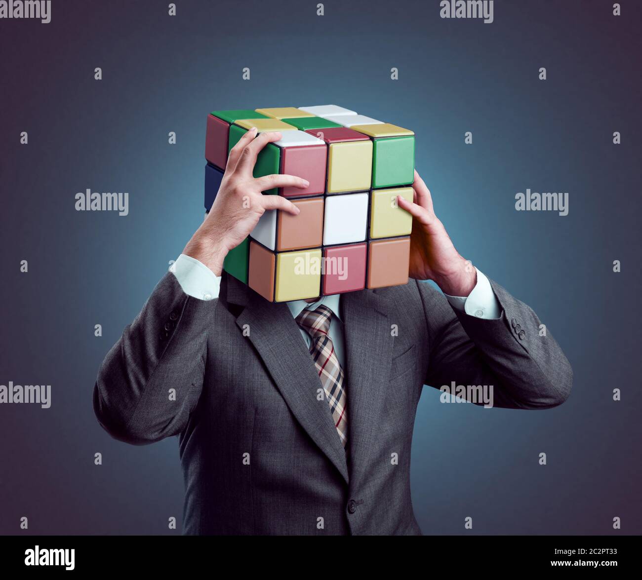Businessman holding his rubik cube head isolated on gray Stock Photo ...