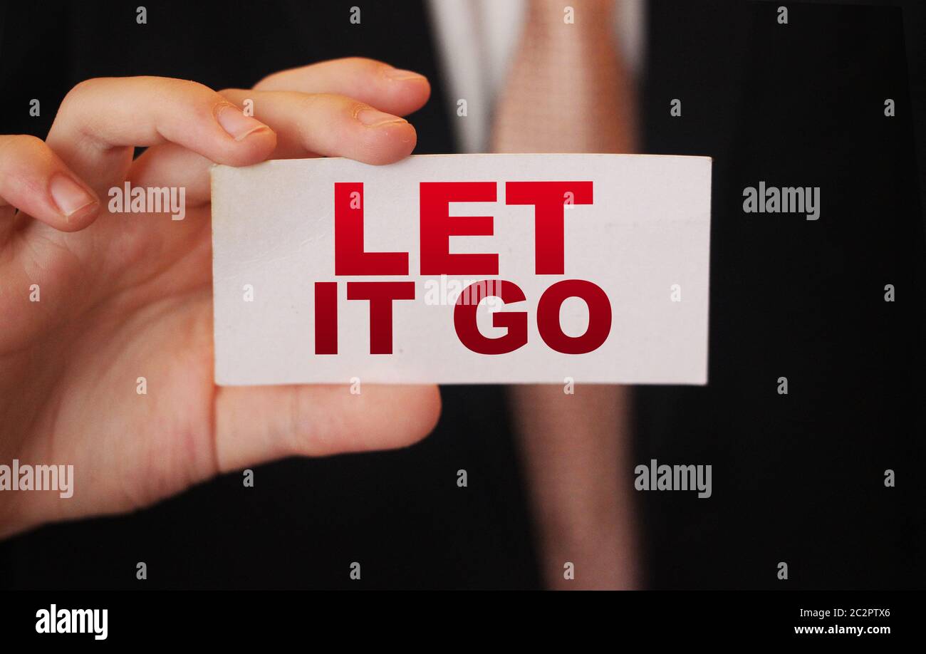 Closeup on businessman holding a card with text LET IT GO, business ...