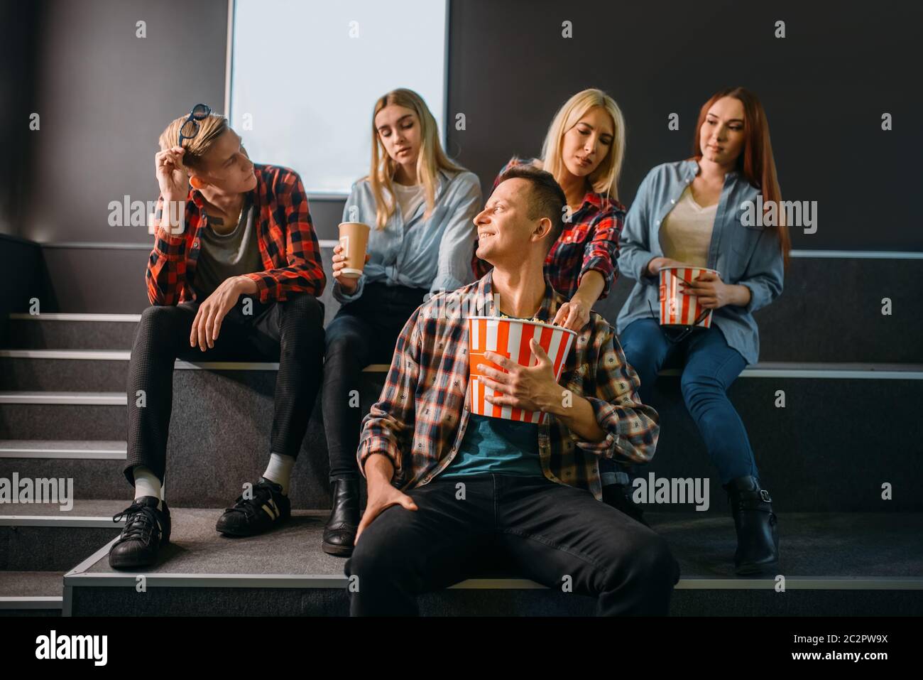 Group of friends having fun in cinema hall before the showtime. Male ...